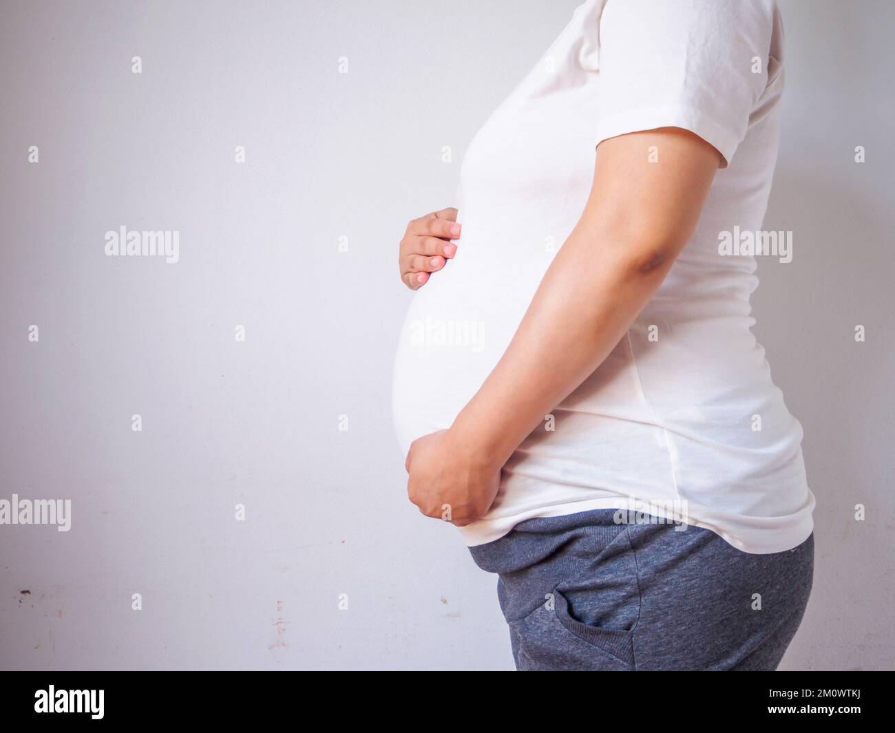 pregnant woman touching her belly Stock Photo - Alamy