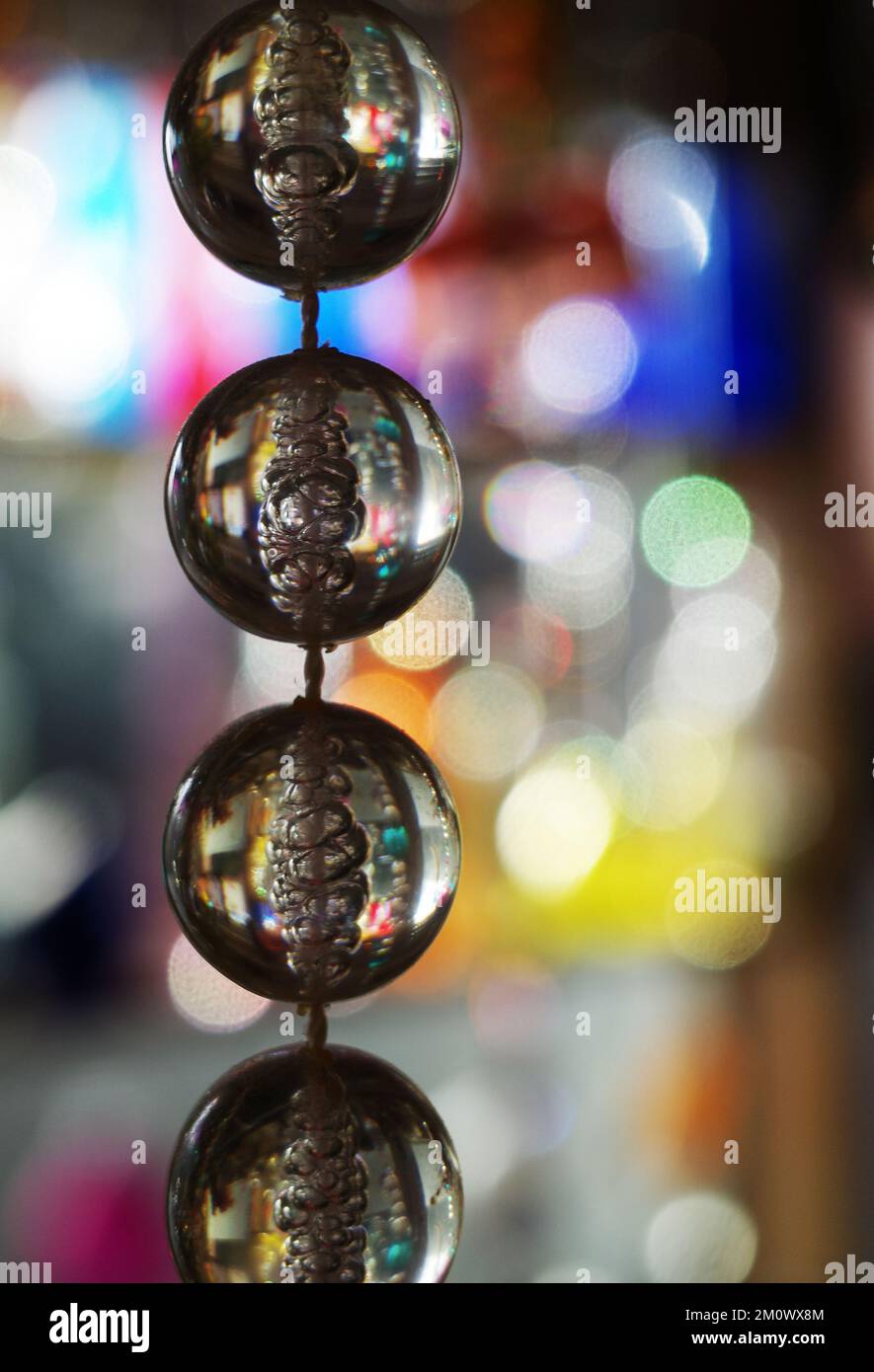 A strand of hanging glass beads on a thread. Bokeh background Stock ...