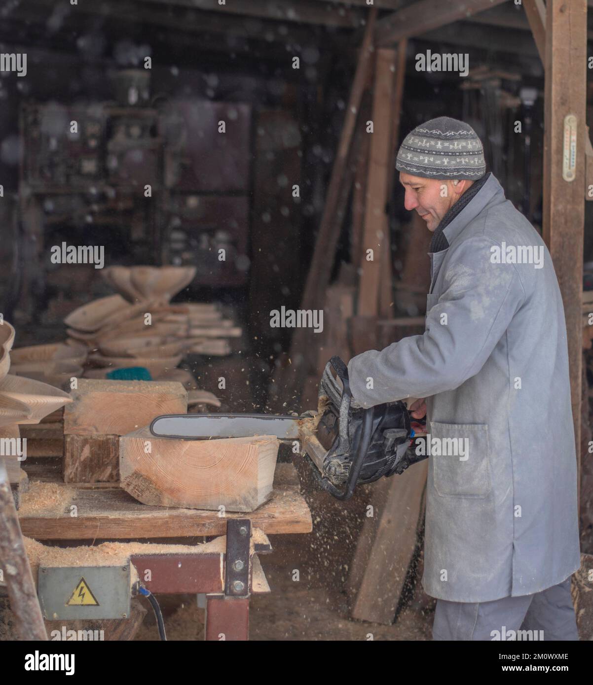 The work of a wood artist with a chainsaw in the workshop Stock Photo ...