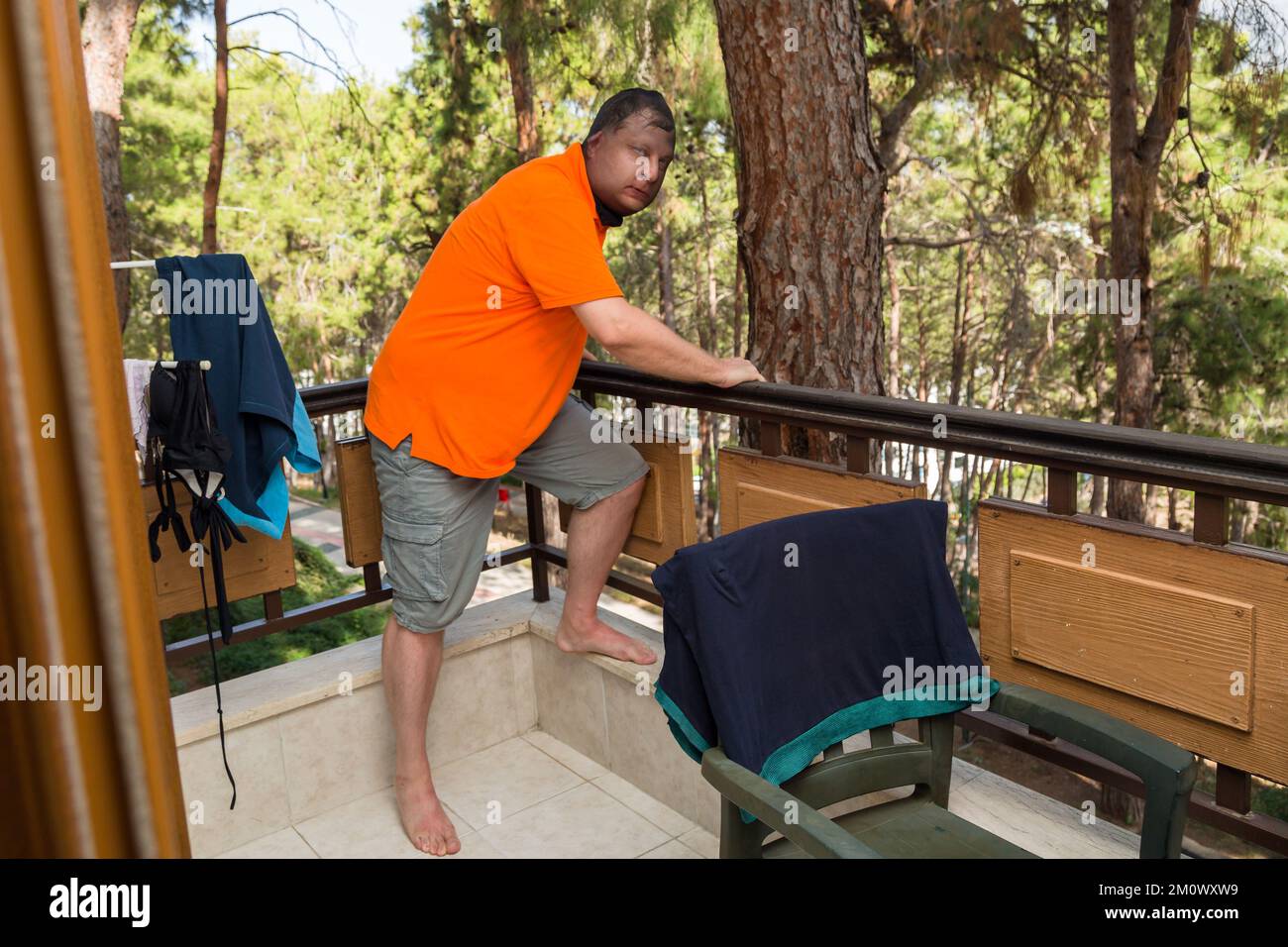 thief climbed onto the balcony of house. Robber in summer clothes with ...