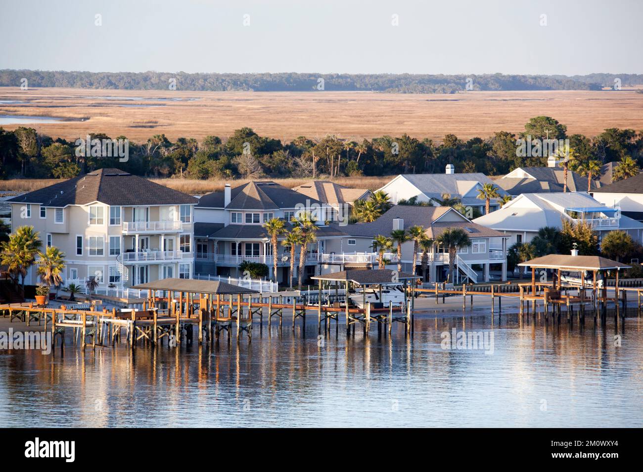 The sunset view of residential houses with wooden piers on Little Marsh ...