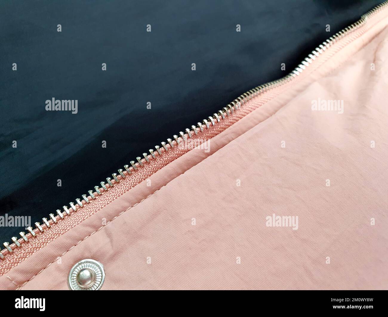 Zipper lock on Down jacket fabric background, pink puffer jacket and ...