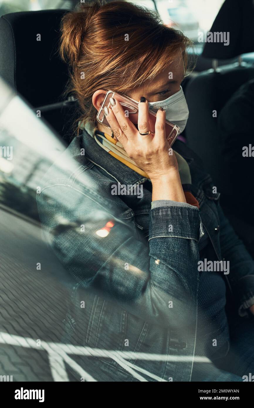 Woman talking on phone using smartphone sitting in a car wearing the ...