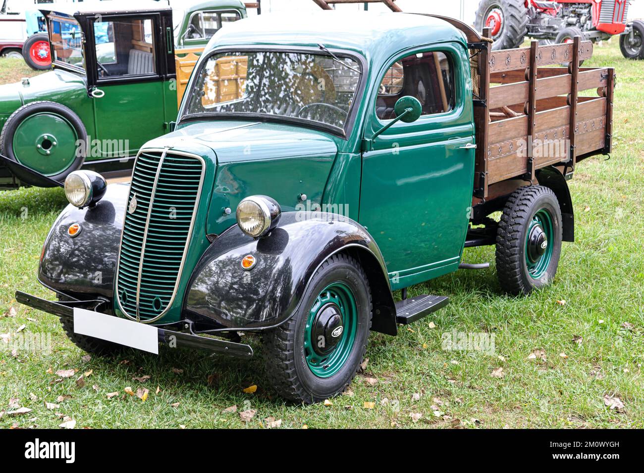 A side view of a classic Ford pickup truck with a wooden trunk in a ...