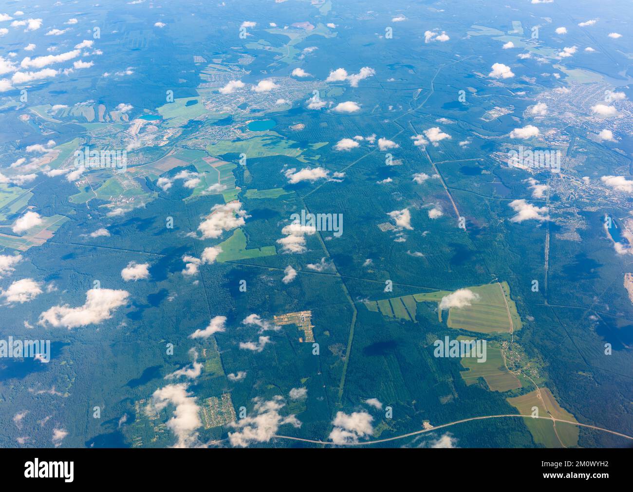 Aerial view from airplane window above green ground. View from the ...