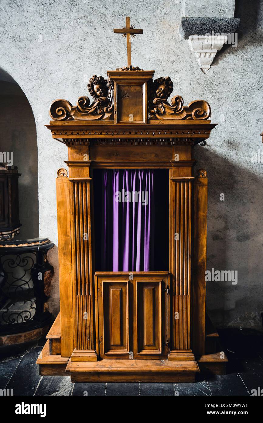 Typical old wooden confession booth at a church, with blue curtains ...