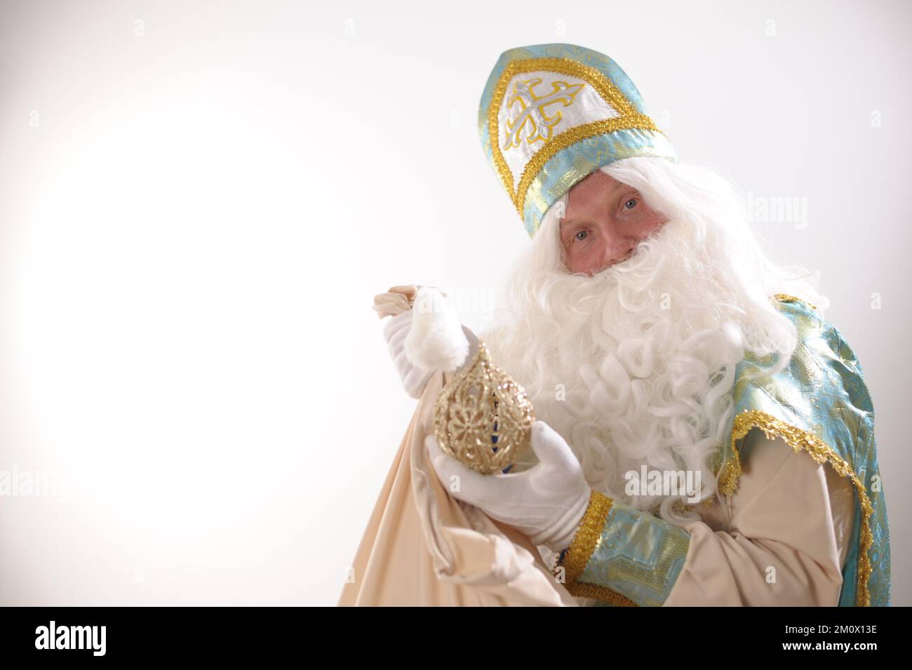 Nicholas the Wonderworker takes out a toy from bag gold suit long white ...