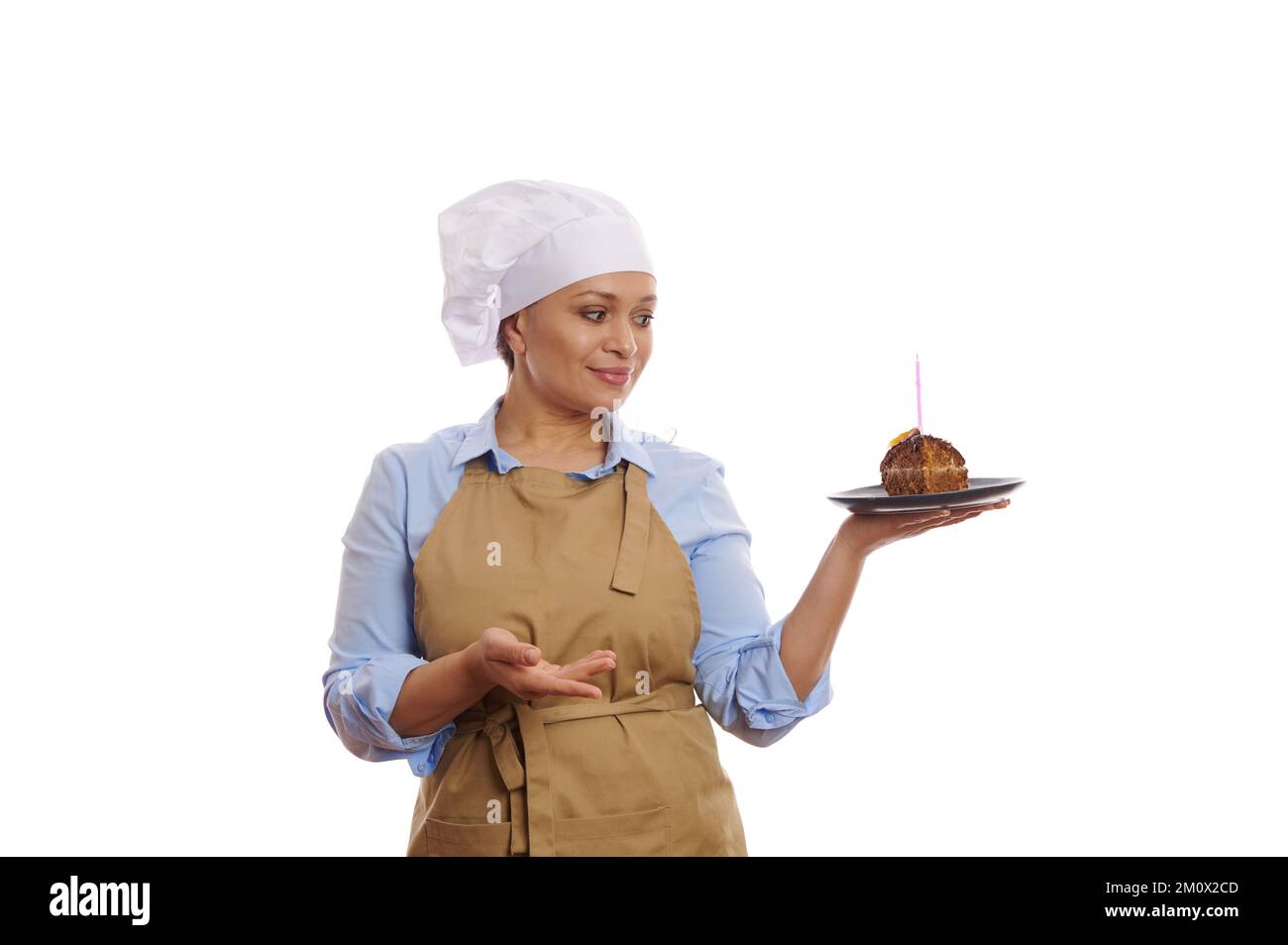Pleasant woman cook, chef confectioner in apron and hat, shows on ...