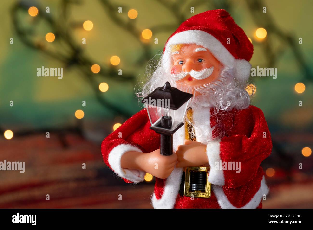 Santa claus doll with blurred christmas lights background Stock Photo ...