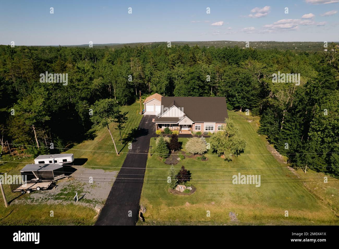 A drone view of a house with a driveway surrounded with greenery Stock ...