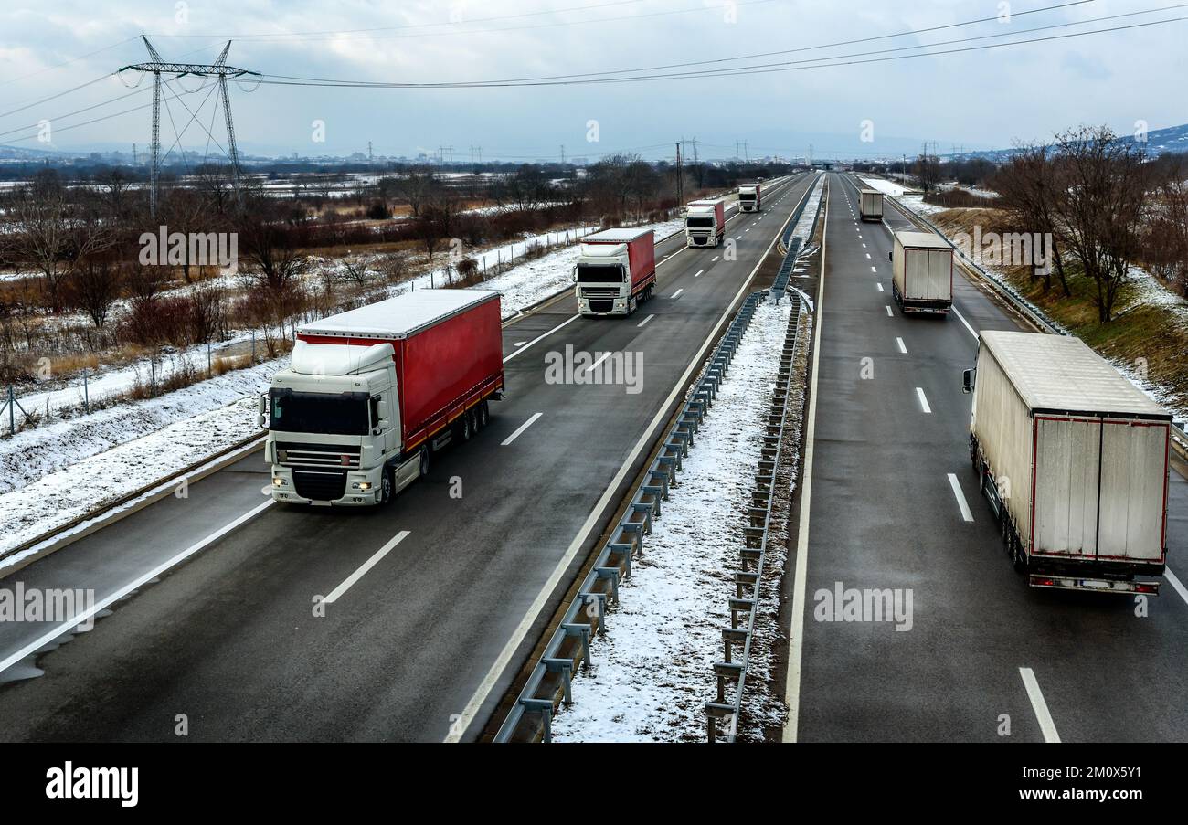 Convoy of Transportation Lorry Trucks on a Highway in a snowy winter ...