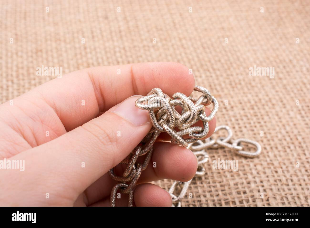 Chain made of gold color in hand Stock Photo - Alamy