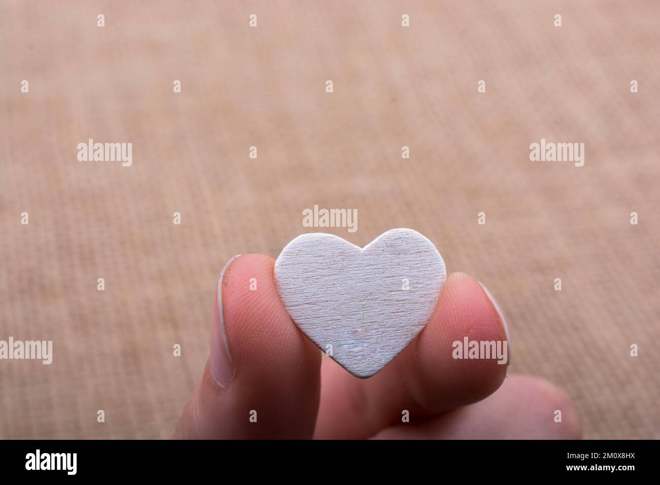 Heart shaped object in hand on canvas Stock Photo - Alamy