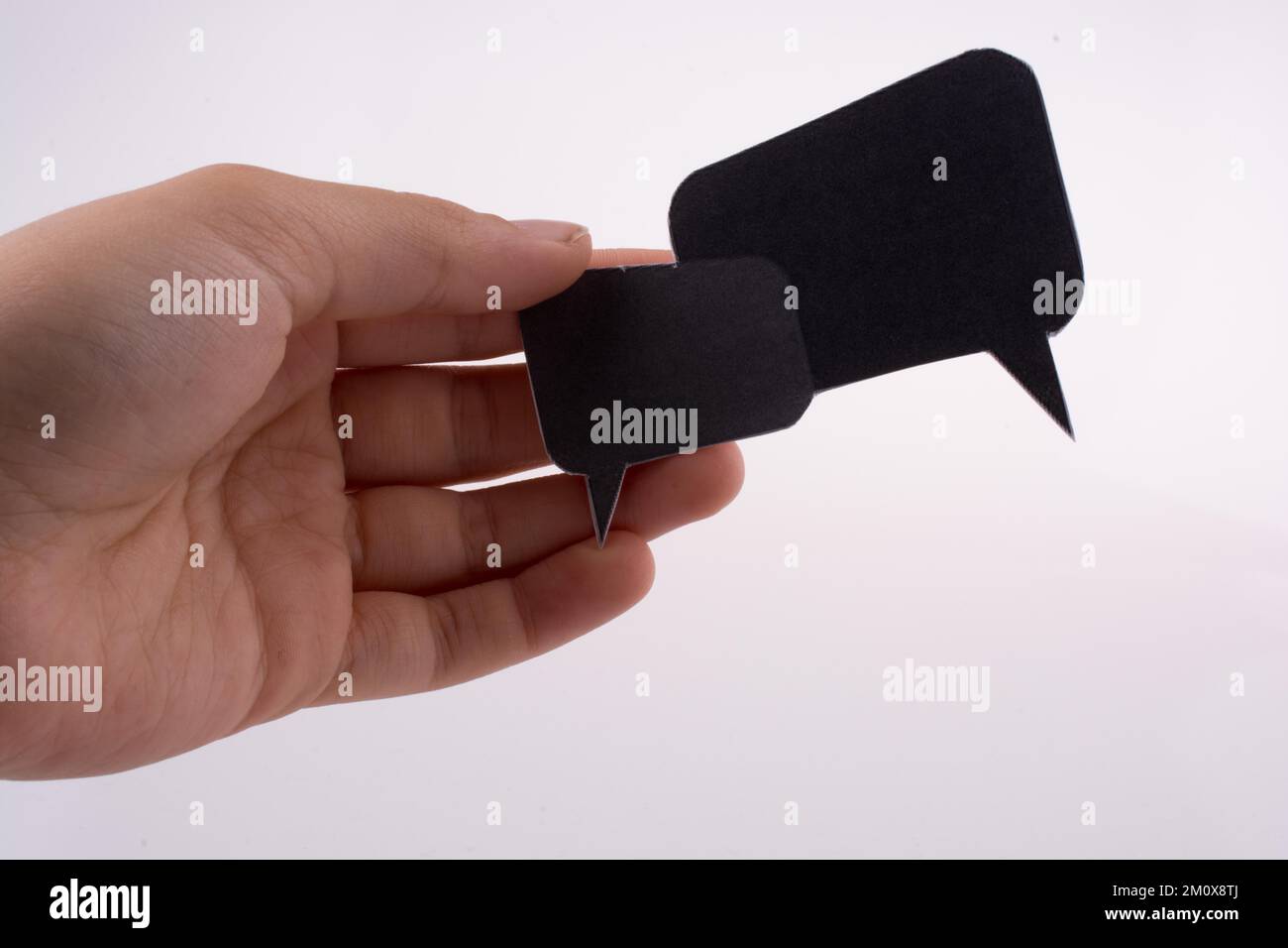 Hand holding dialogue boxes on a white background Stock Photo - Alamy