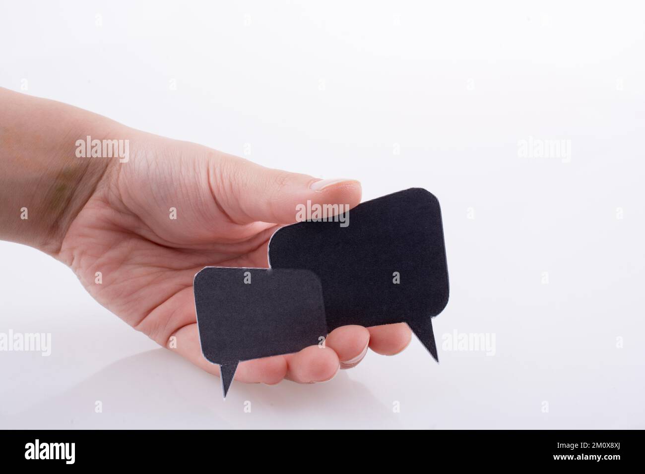 Hand holding dialogue boxes on a white background Stock Photo - Alamy