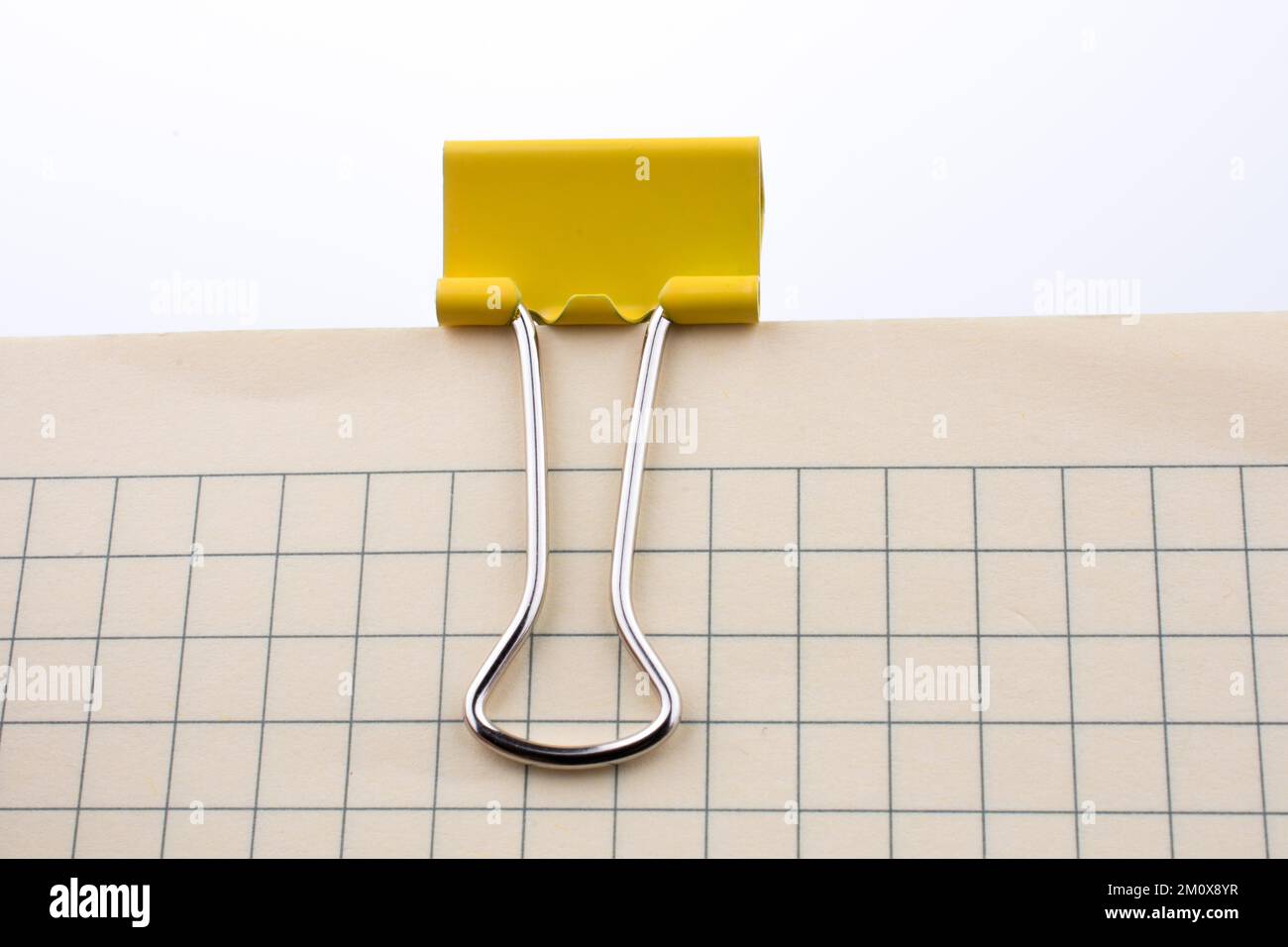 Colored paper clip on a checked notebook page Stock Photo - Alamy