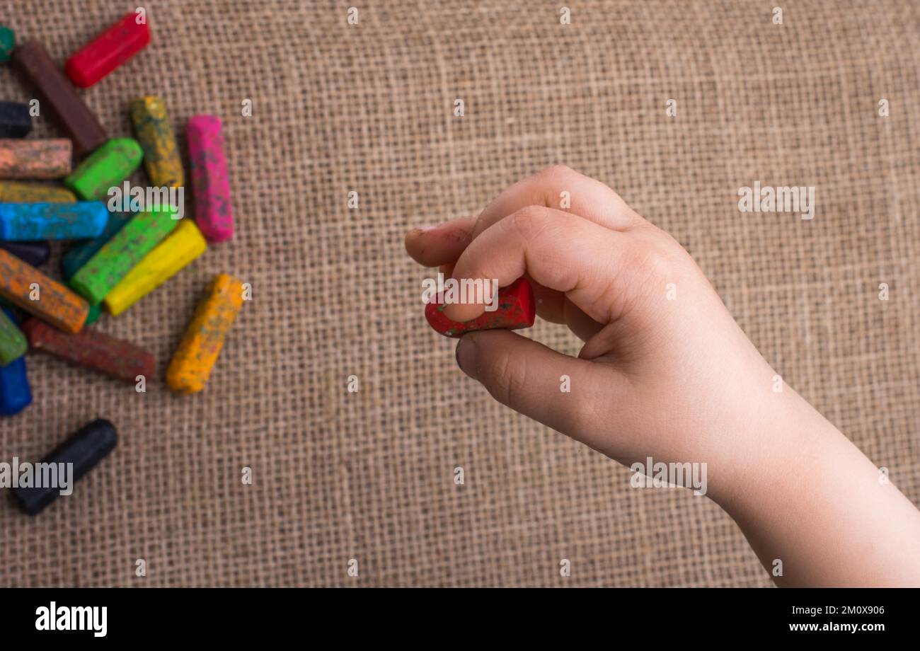 Used color crayons and a toddlers hand holding one Stock Photo - Alamy
