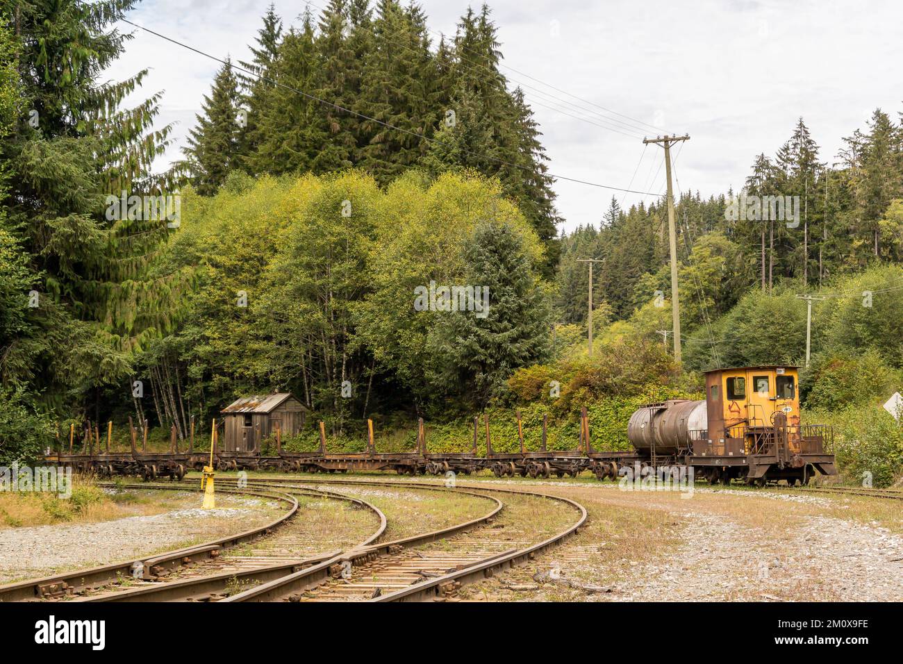 The old logging railway tracks with a caboose and train Stock Photo - Alamy