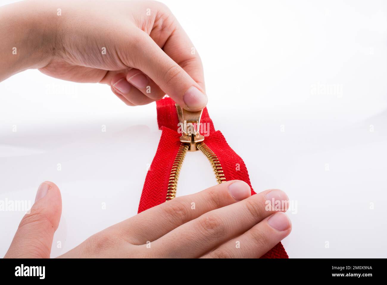 Hand holding color zipper on a white background Stock Photo - Alamy