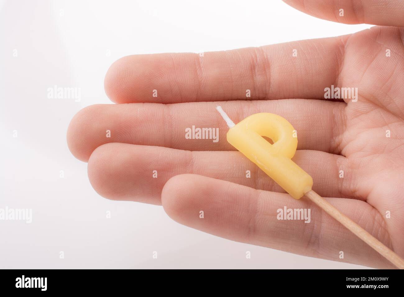 Color candle in hand on sticks writes the letter P Stock Photo - Alamy