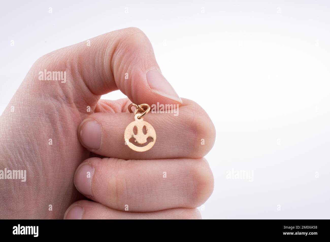 Hand holding a golden color smiley Stock Photo - Alamy