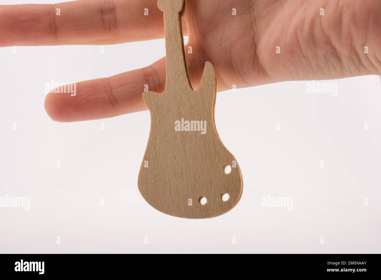 Mini wooden guitar model in hand on a white background Stock Photo - Alamy