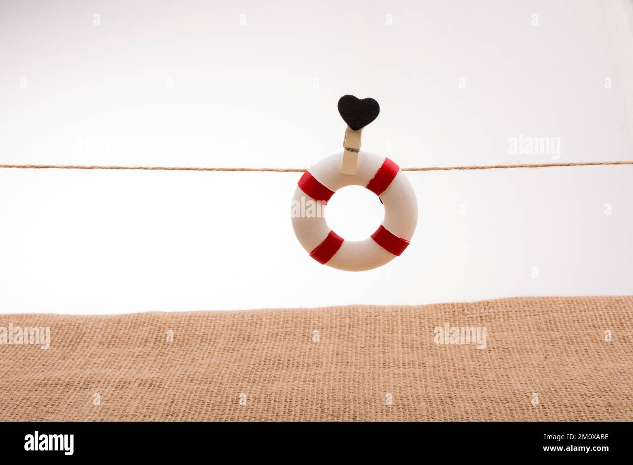 Life preserver attached to a string with heart icon Stock Photo - Alamy