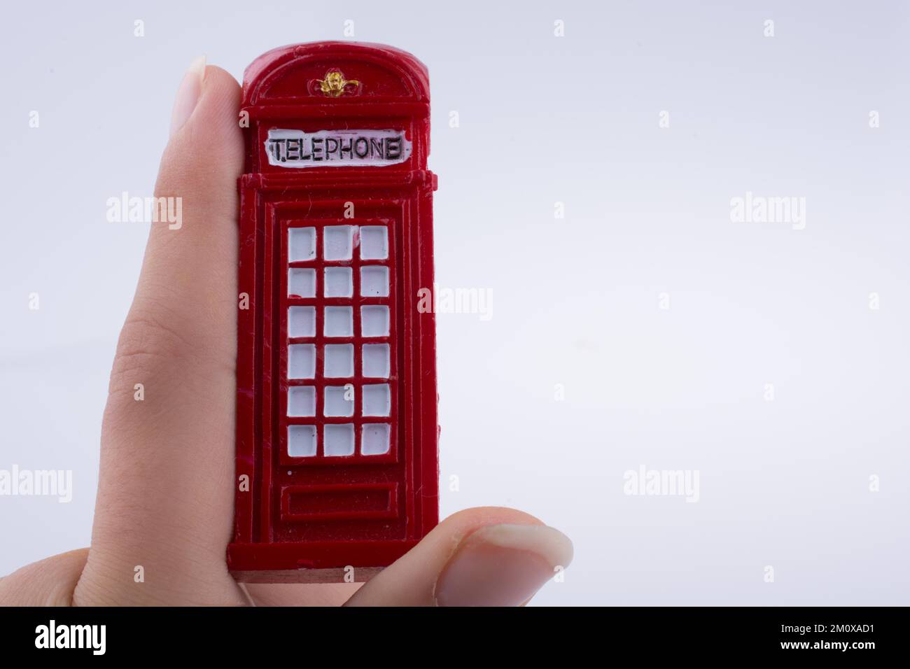 Hand holding a red color phone booth on a white background Stock Photo ...