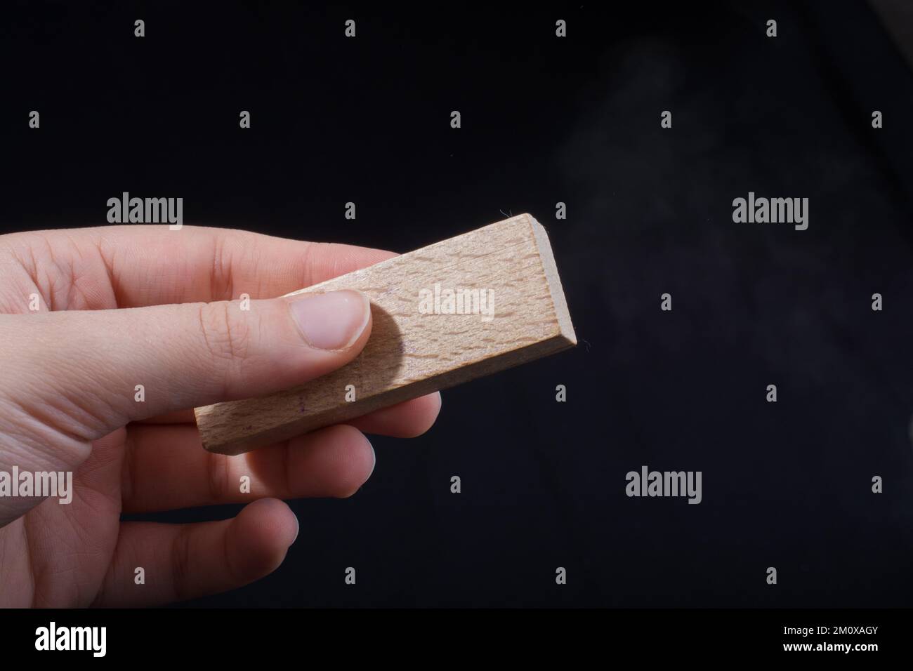 Small piece of cut wood in hand background Stock Photo - Alamy