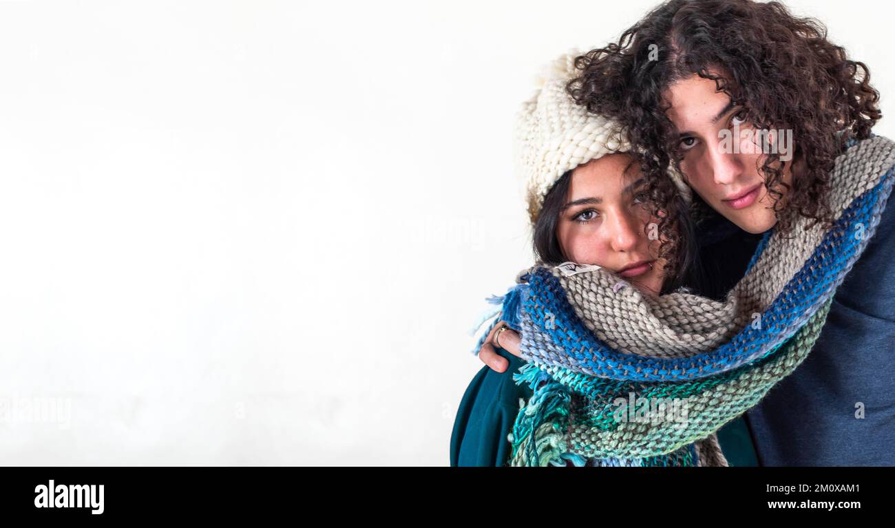 Two friends are hugging each other like they are cold while wearing the ...