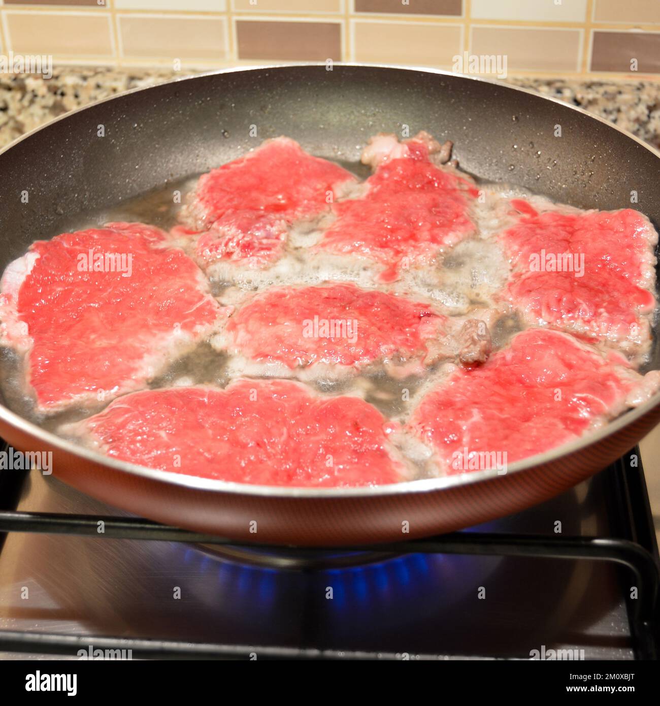 Fresh red cow tenderloin frying in pan on stove, homemade very healthy ...