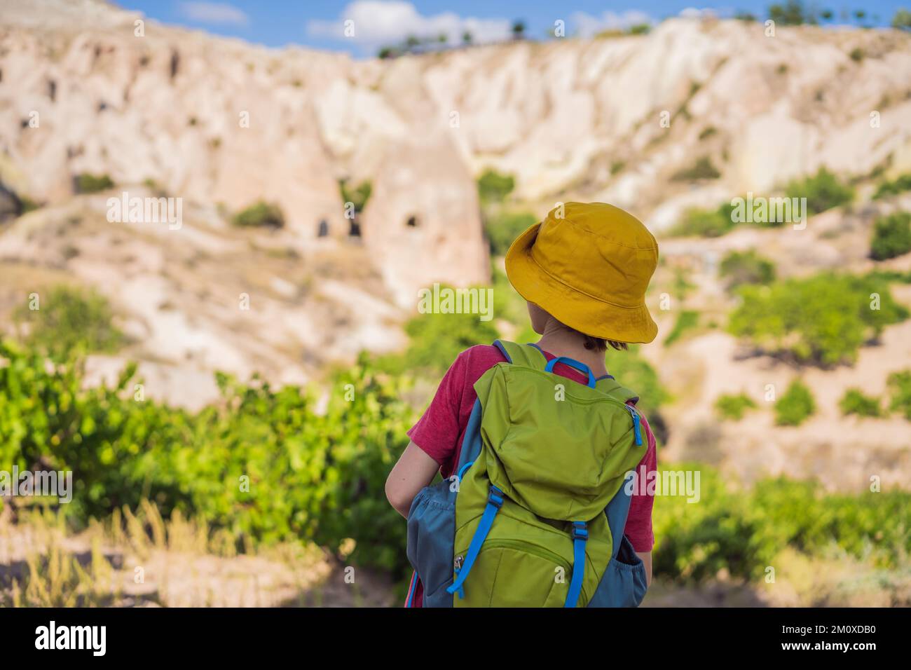 Boy tourist exploring valley with rock formations and fairy caves near ...