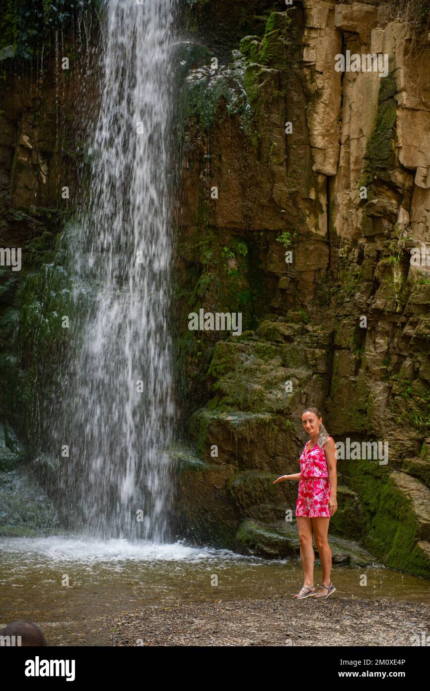 one girl in a pink dress stands at a waterfall Stock Photo - Alamy