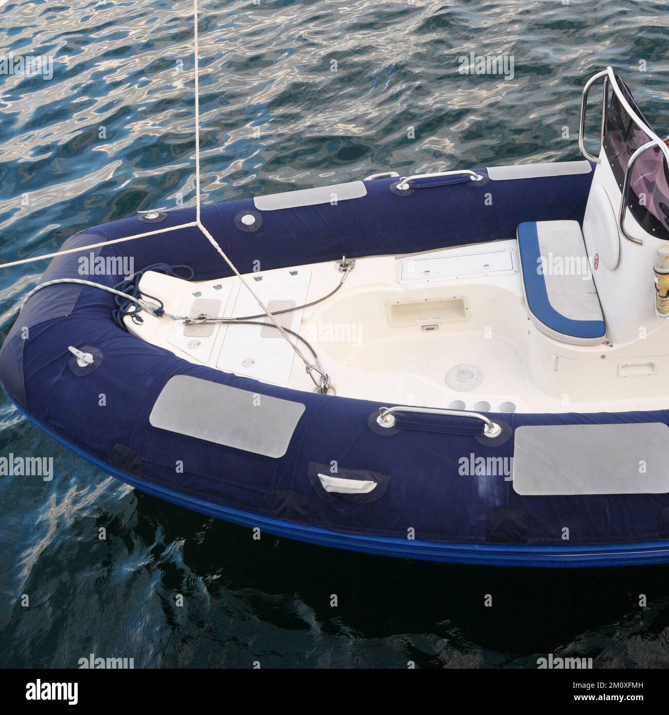 Modern inflatable boat with engine in the sea near shore, blue white ...