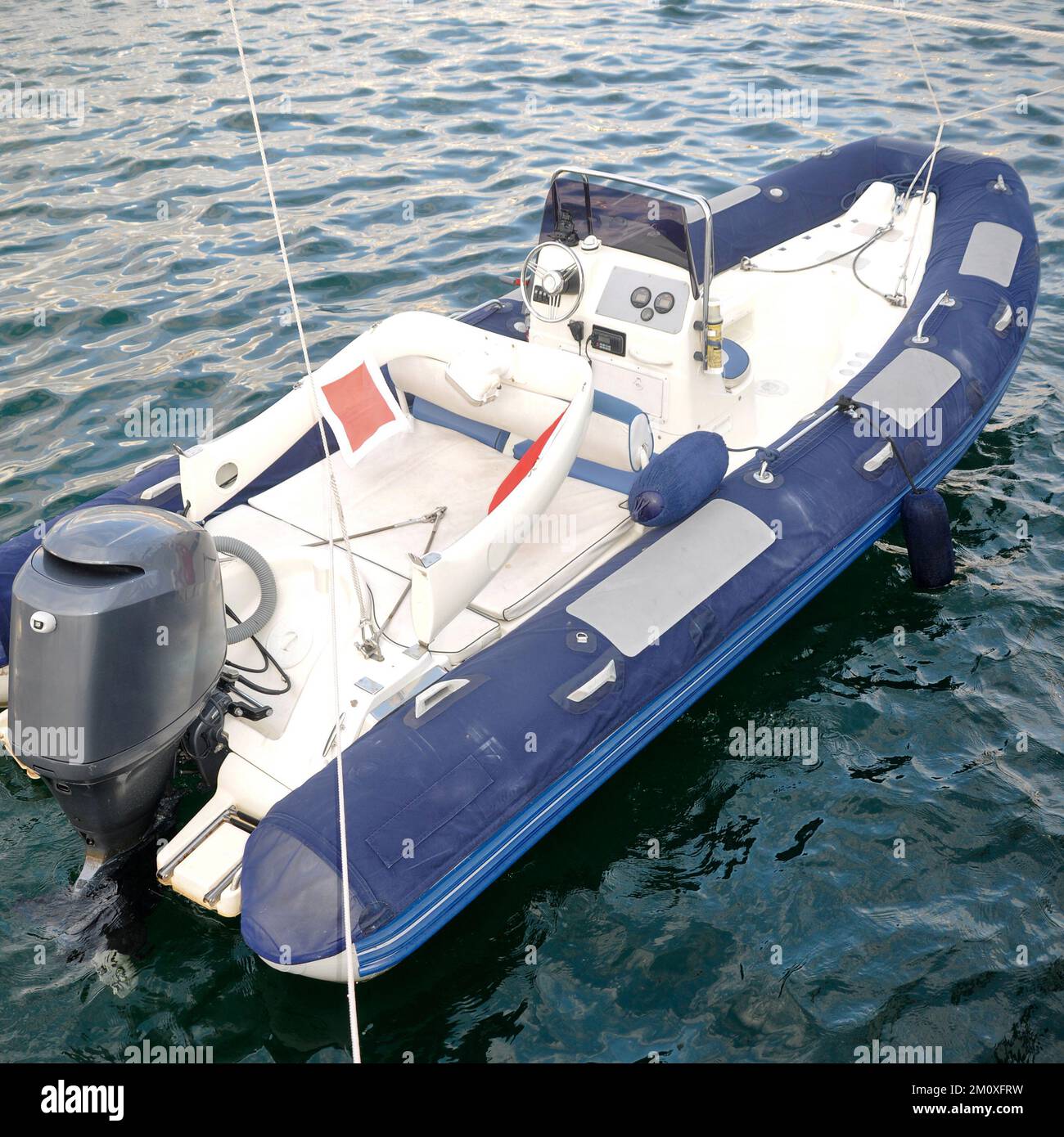 Modern inflatable boat with engine in the sea near shore, blue white ...