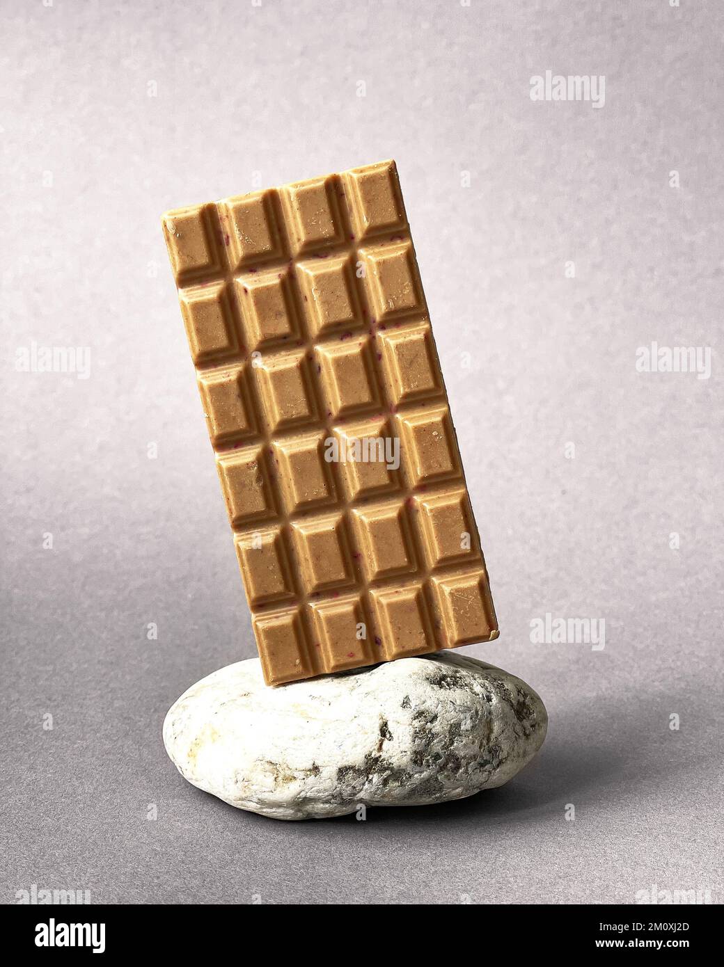 Bar of white chocolate on stone gray background. Side view. Place for ...