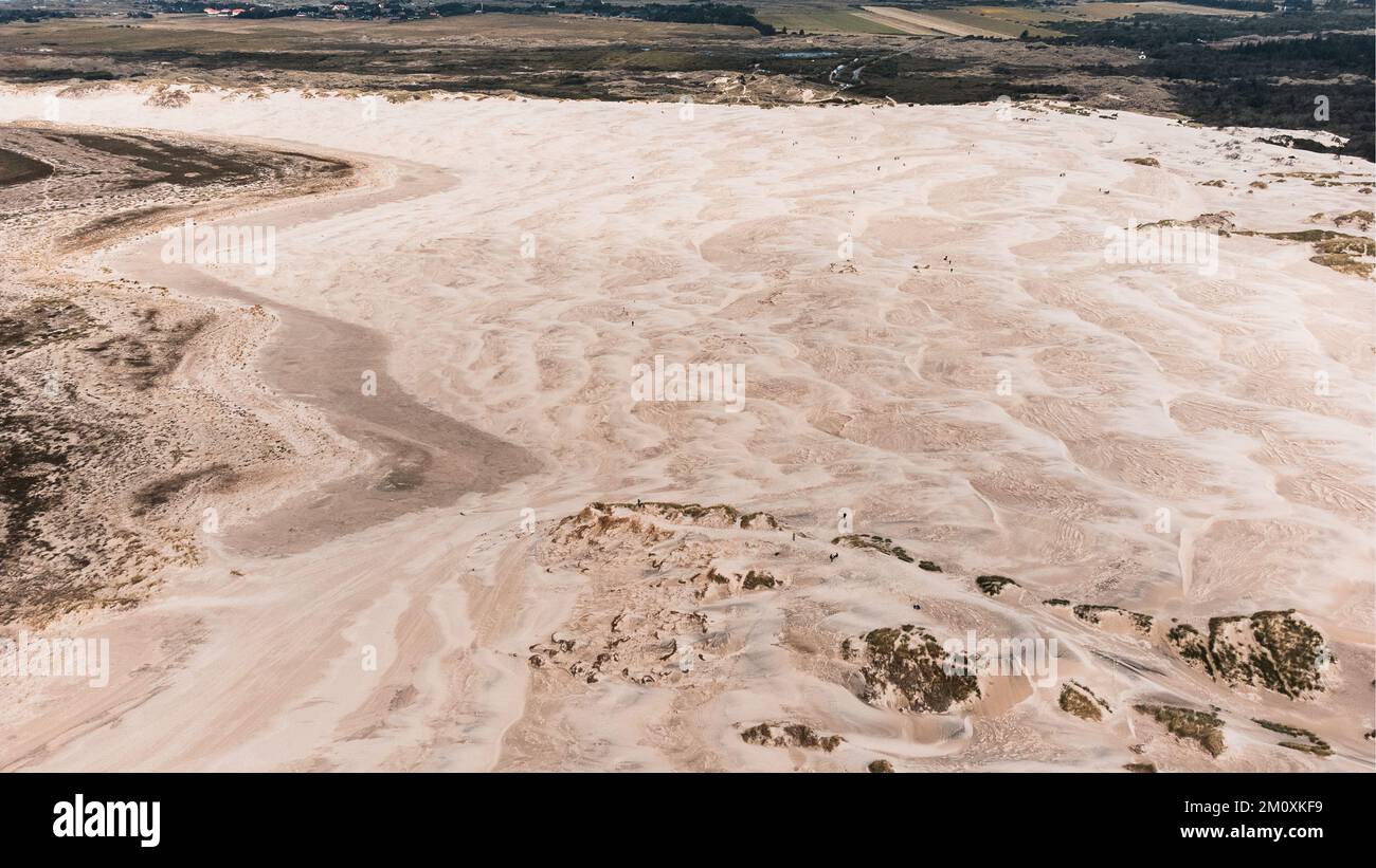 A beautiful scene of Rabjerg Mile sand dunes with plants on the horizon ...