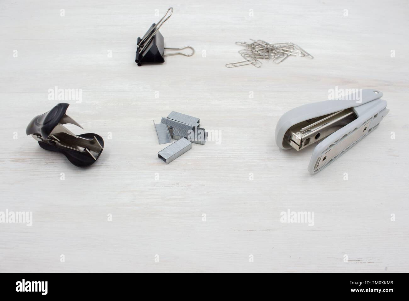 stapler, anti-stapler, Binder Clip, clerical staples on a white wooden ...
