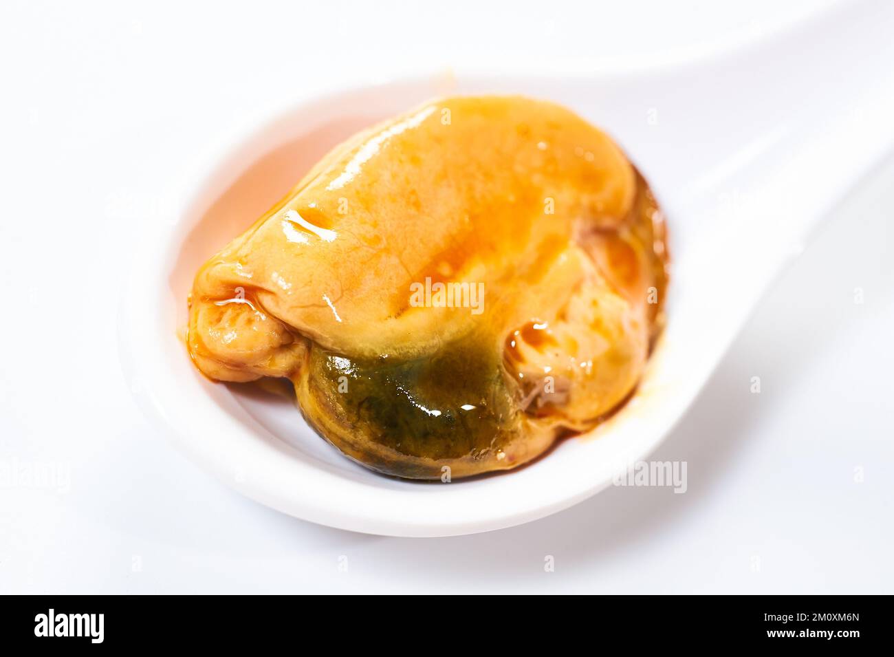 Close-Up of big mussel without shell on a white spoon on a white ...