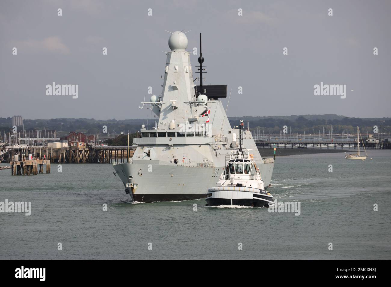 The tug TEMPEST escorts the warship HMS DAUNTLESS towards the harbour ...