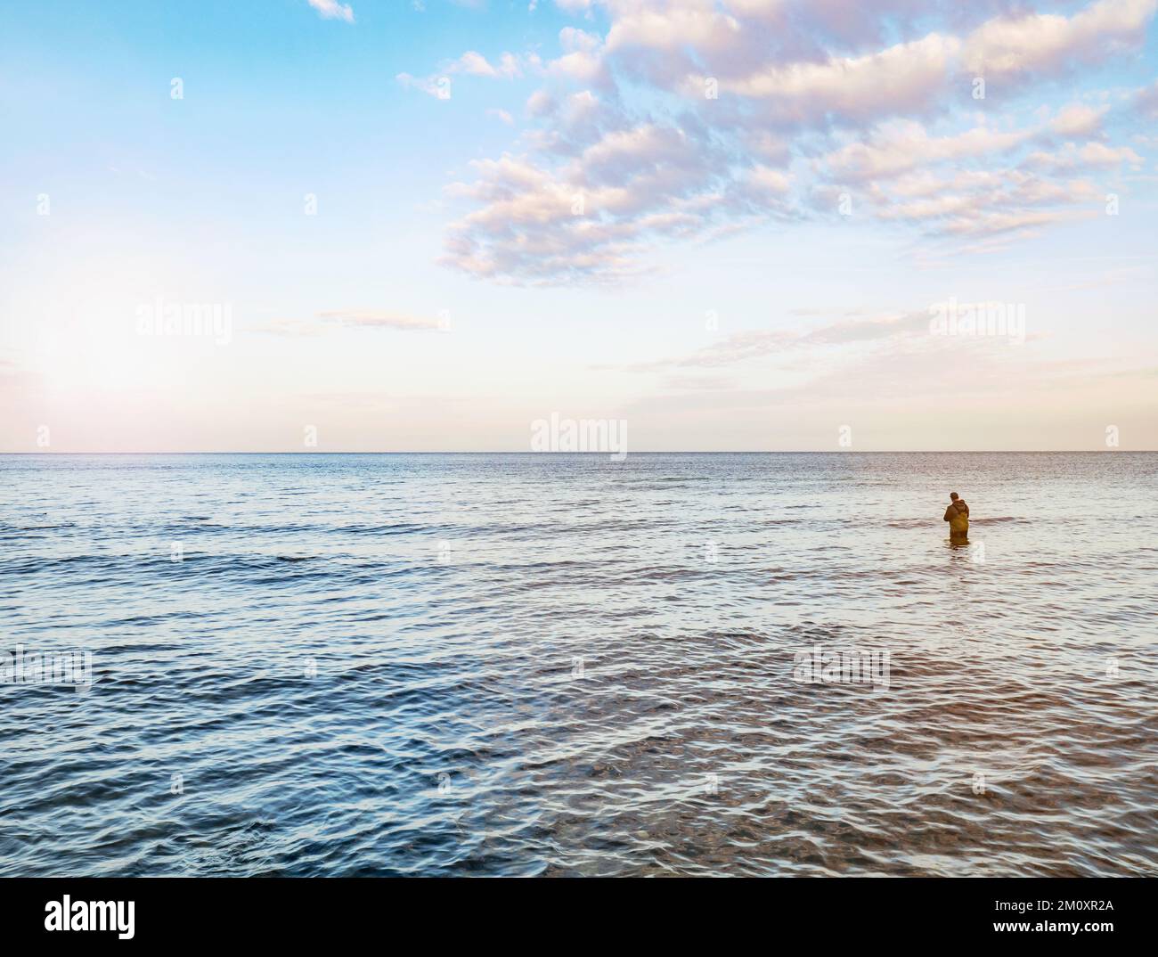 Fisher man stay in the water and pulling bait on his fishing rod ...