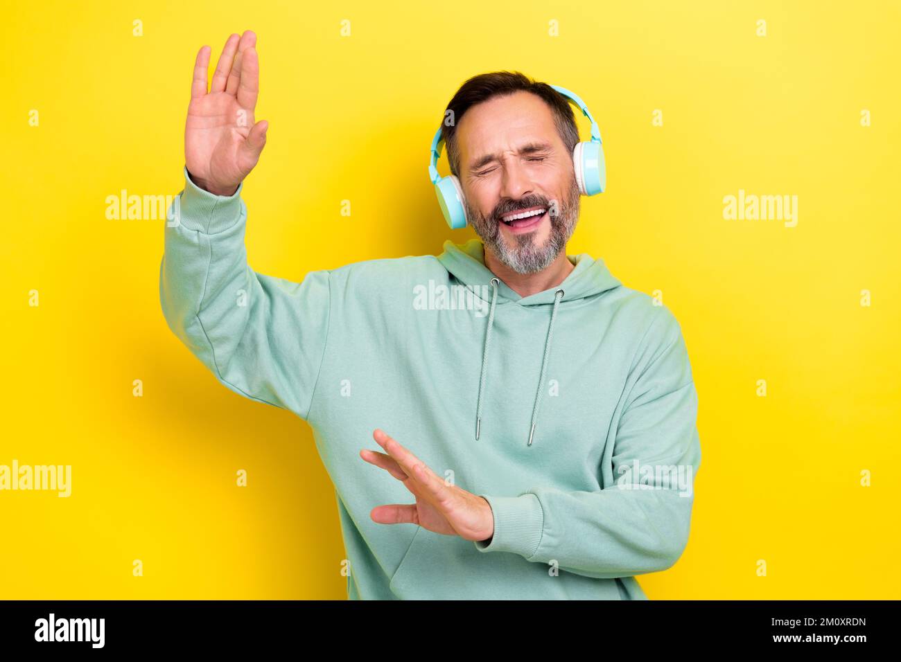 Portrait of satisfied man dressed green hoodie listen favorite music ...