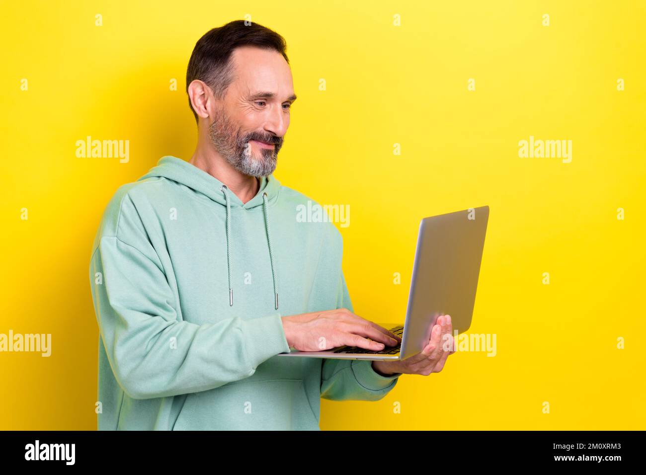 Portrait of positive cheerful handsome man dressed green hoodie look at ...