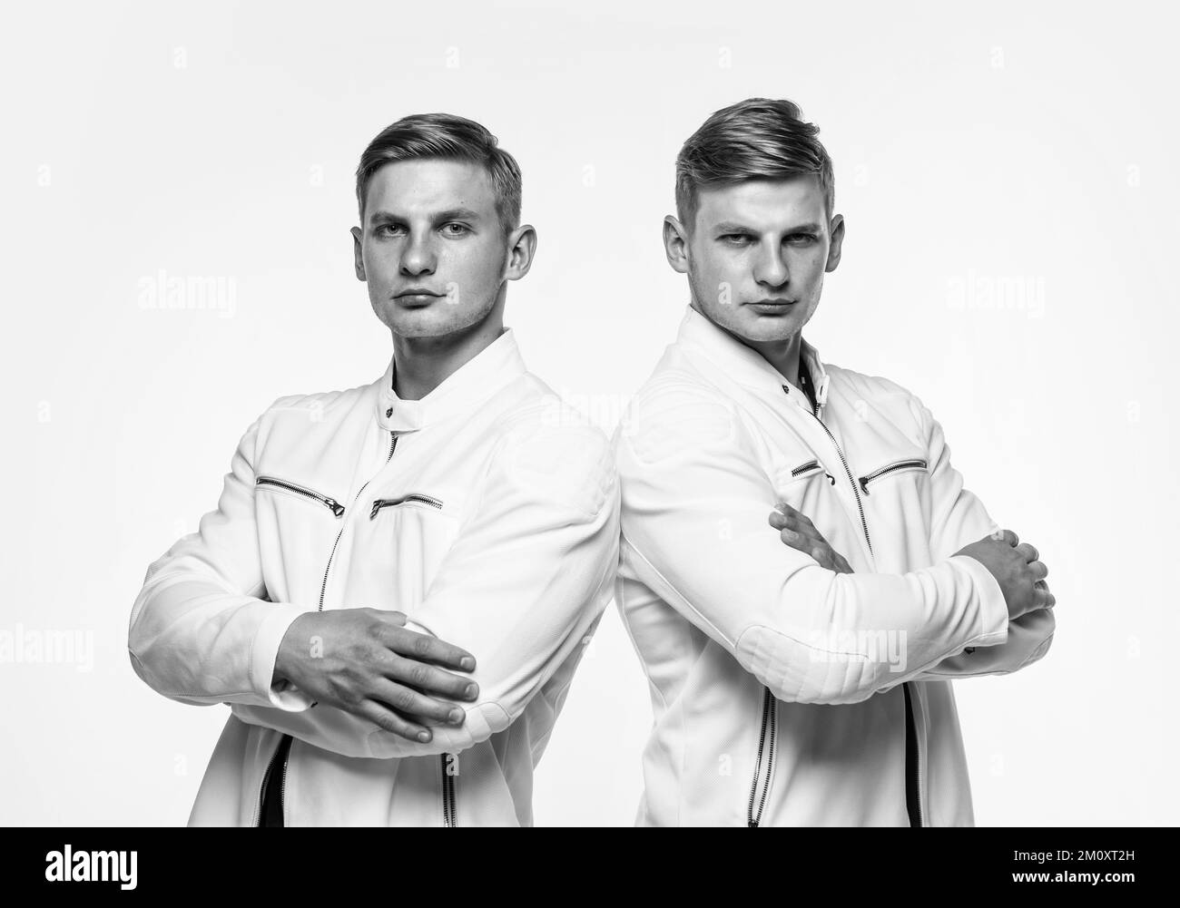 confident fashion models crossed hands. twins brother in white. male ...
