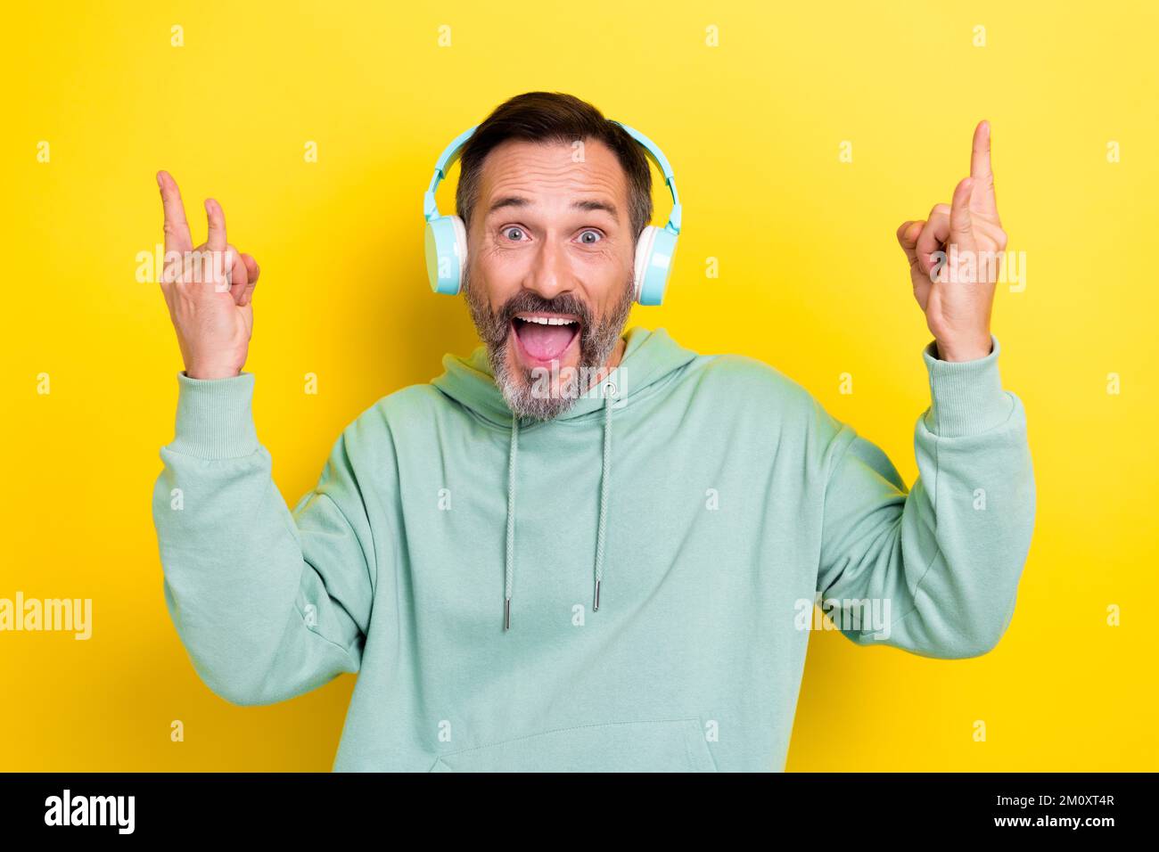 Portrait of positive overjoyed man dressed green hoodie having fun open ...