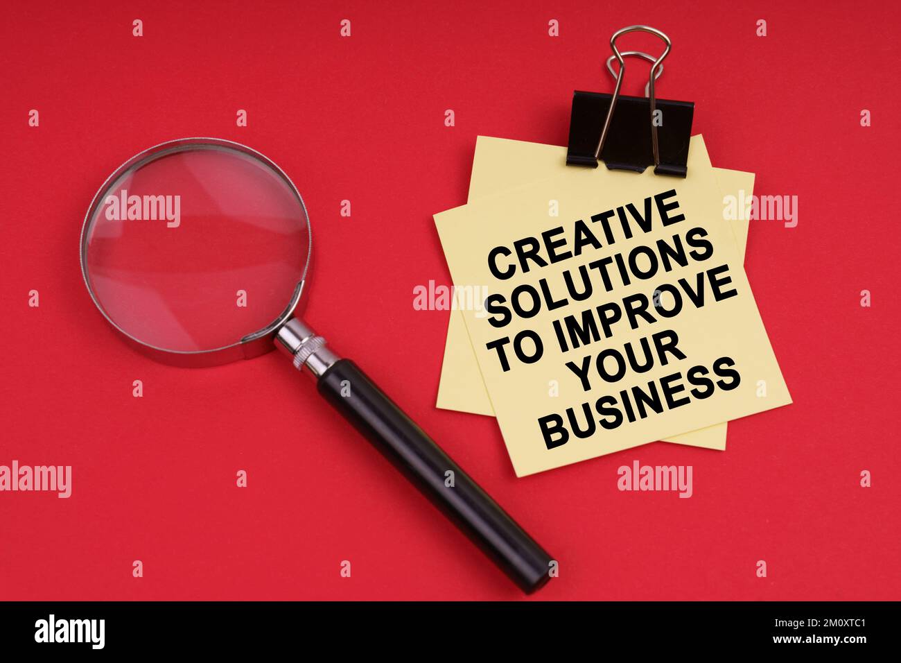 Business and Economics. On a red background, a magnifying glass and a ...