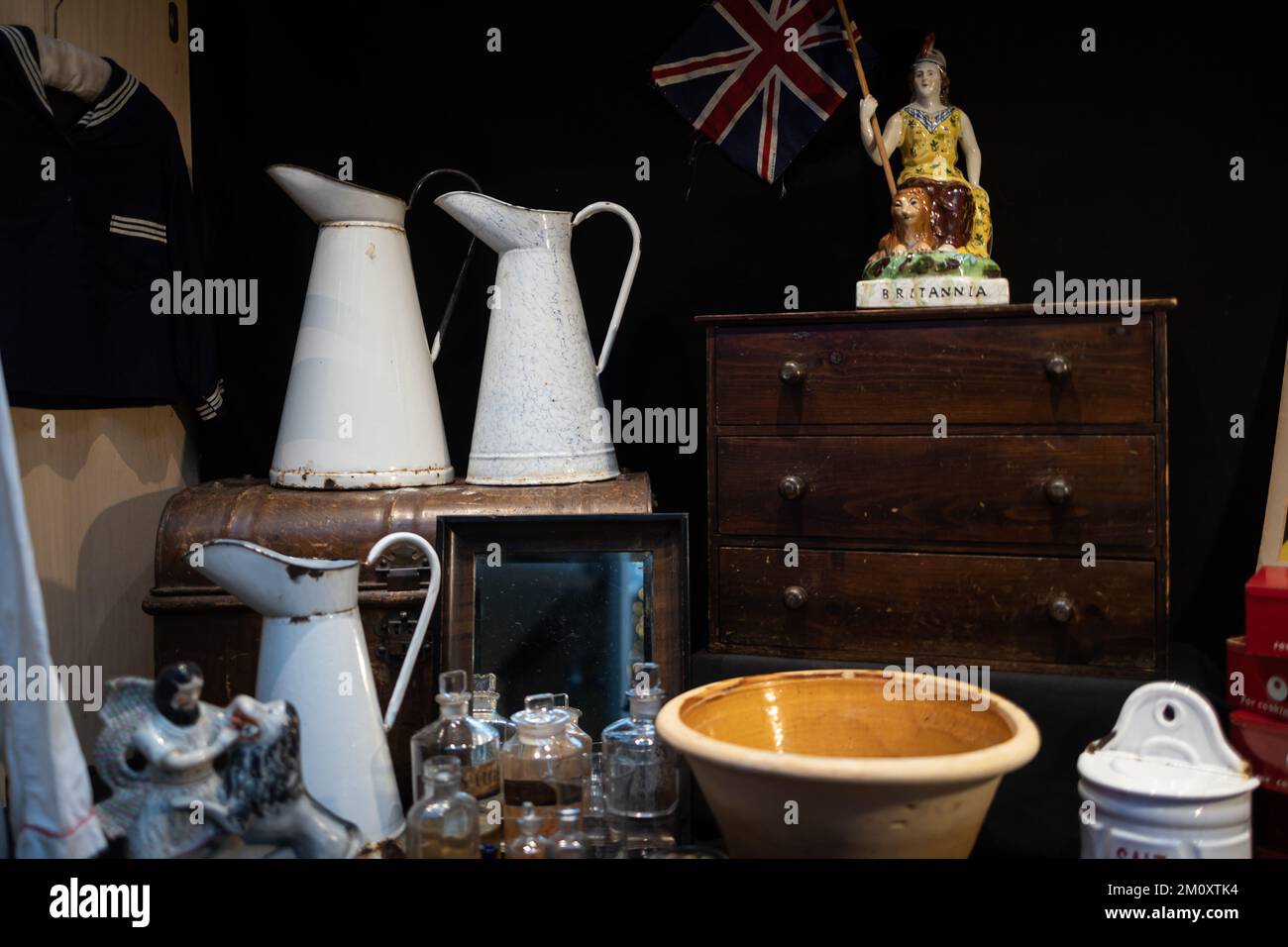 White tin jugs on wooden chest, dresser at vintage flea market Stock ...