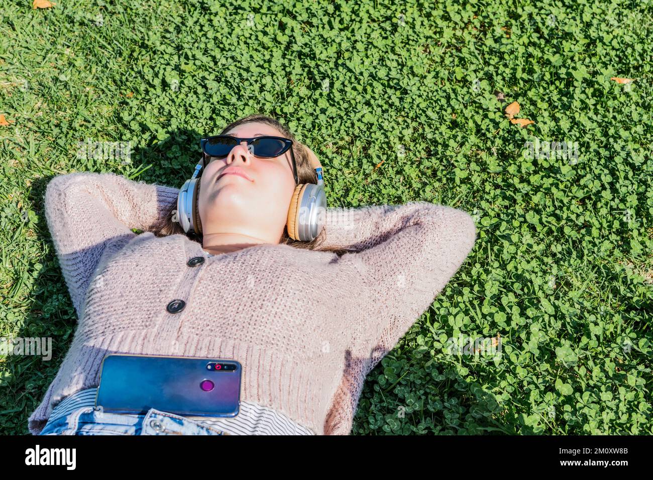 A high angle shot of a young happy female laying on a field and ...