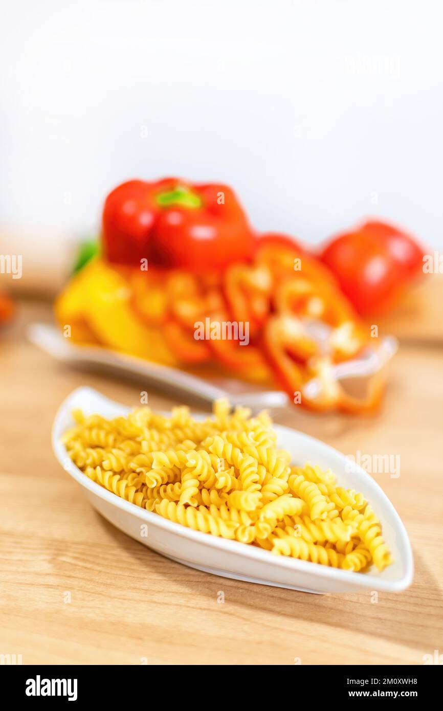 A vertical shot of a plate of raw fusilli pasta on a wooden table Stock ...
