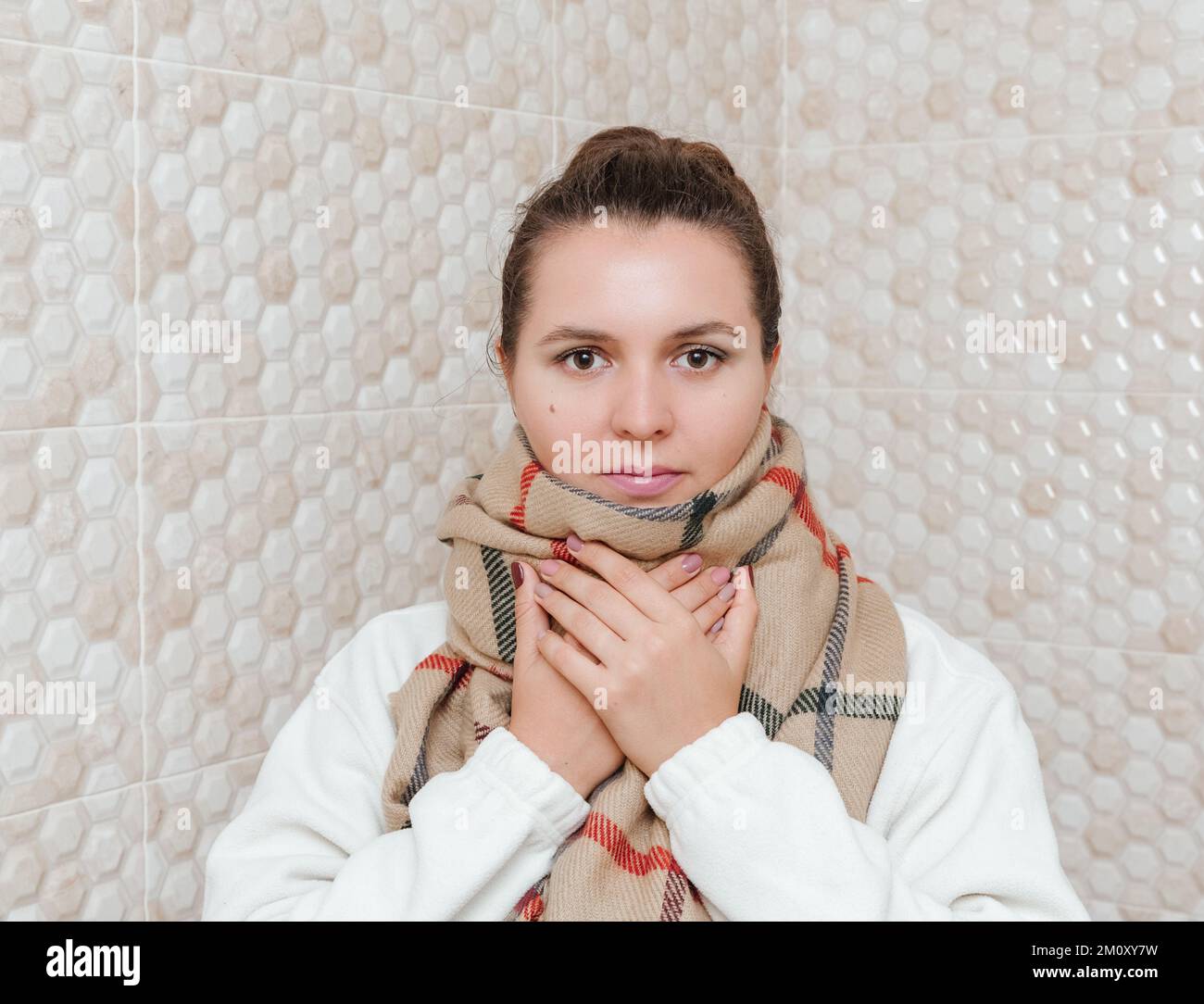 Young girl wrapped in a scarf, suffering from cold, fever, flu ...